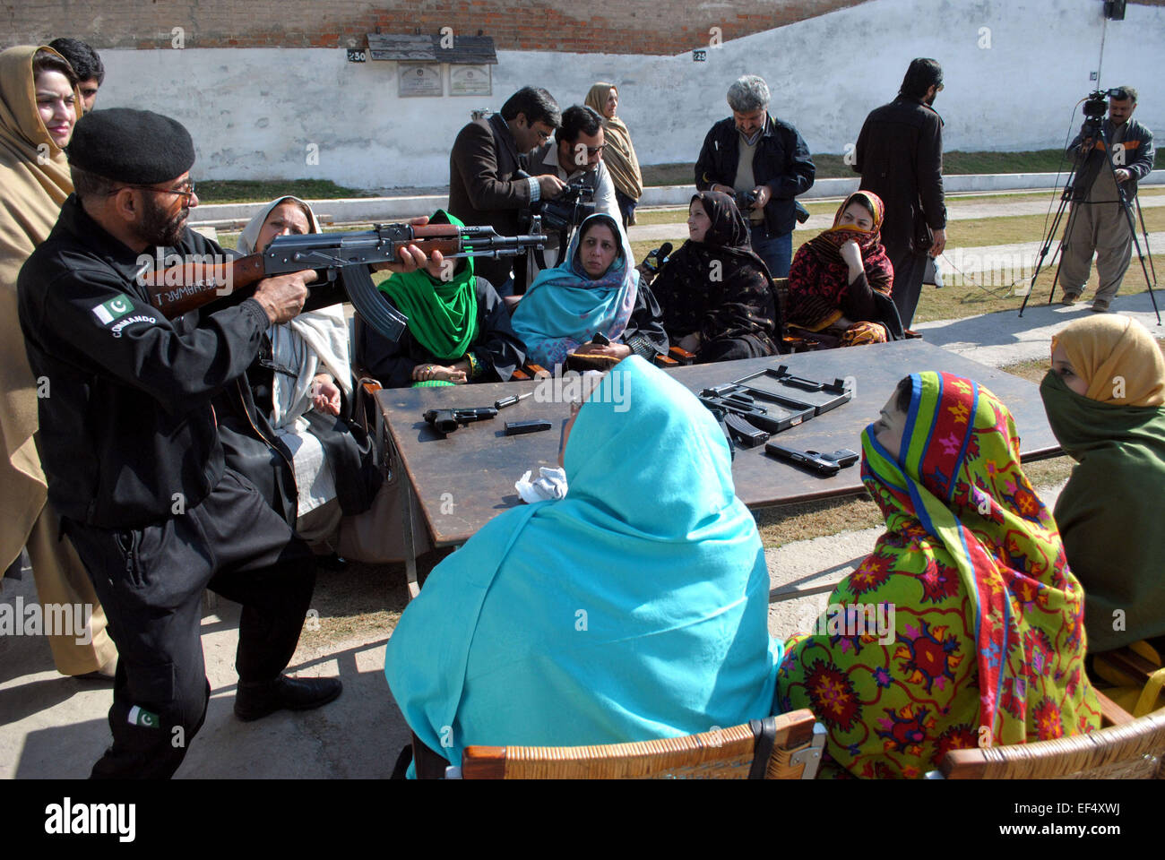 Peshawar. 27th Jan, 2015. A police officer demonstrates how to use an ...