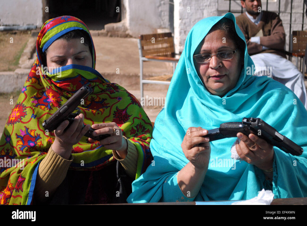 Peshawar. 27th Jan, 2015. Female teachers hold and check guns during a ...