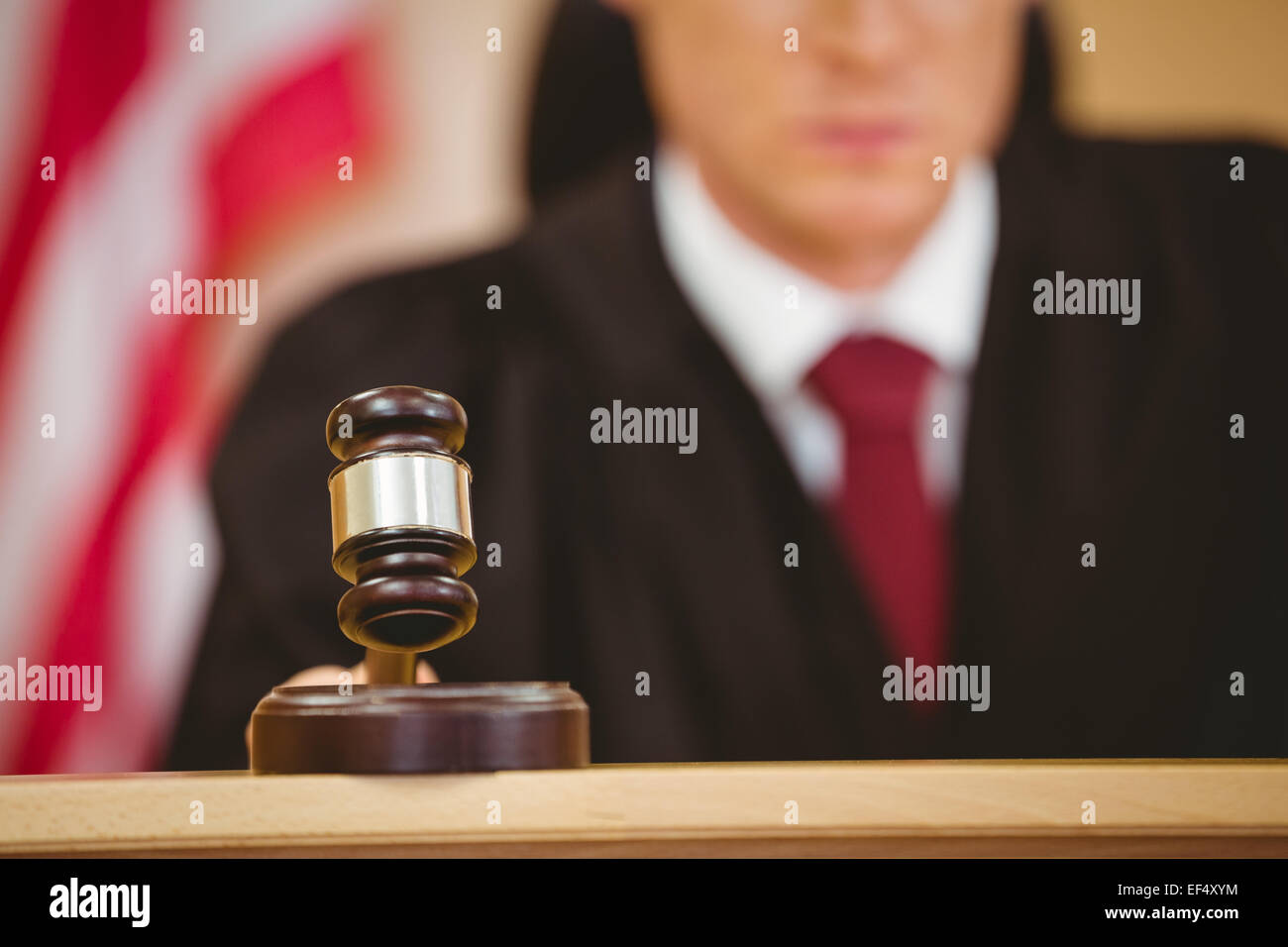 Serious judge about to bang gavel on sounding block Stock Photo - Alamy