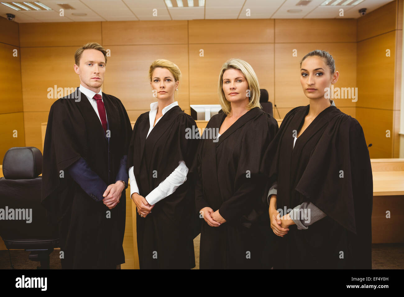Four serious judges standing while wearing robes Stock Photo - Alamy