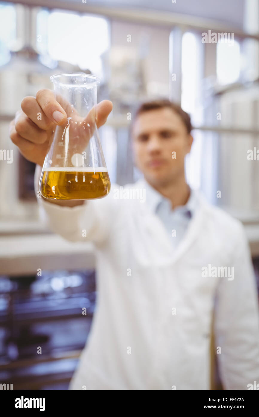 Thoughtful scientist holding a beaker Stock Photo - Alamy