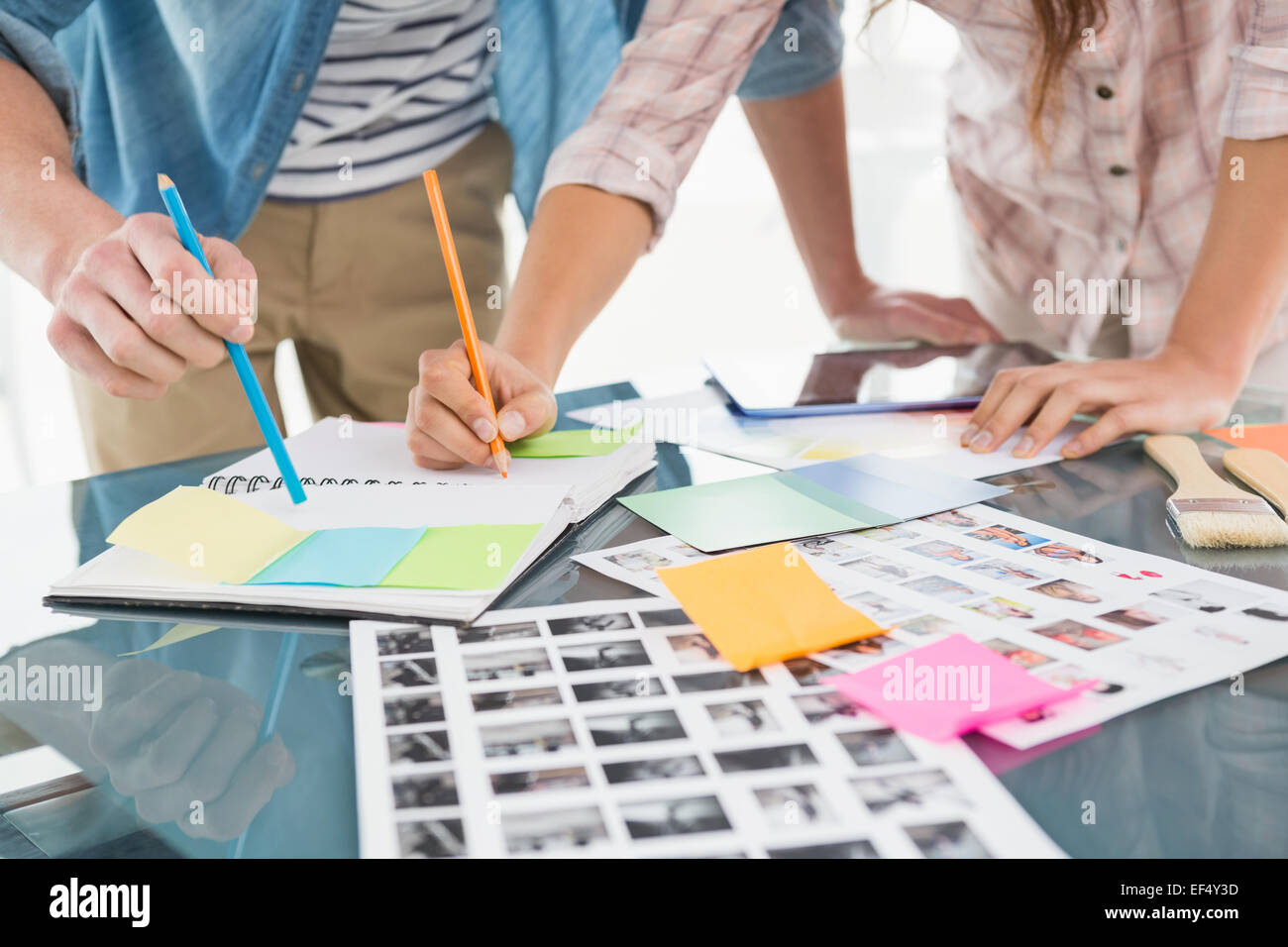 Colleagues writing notes and editing photos Stock Photo - Alamy