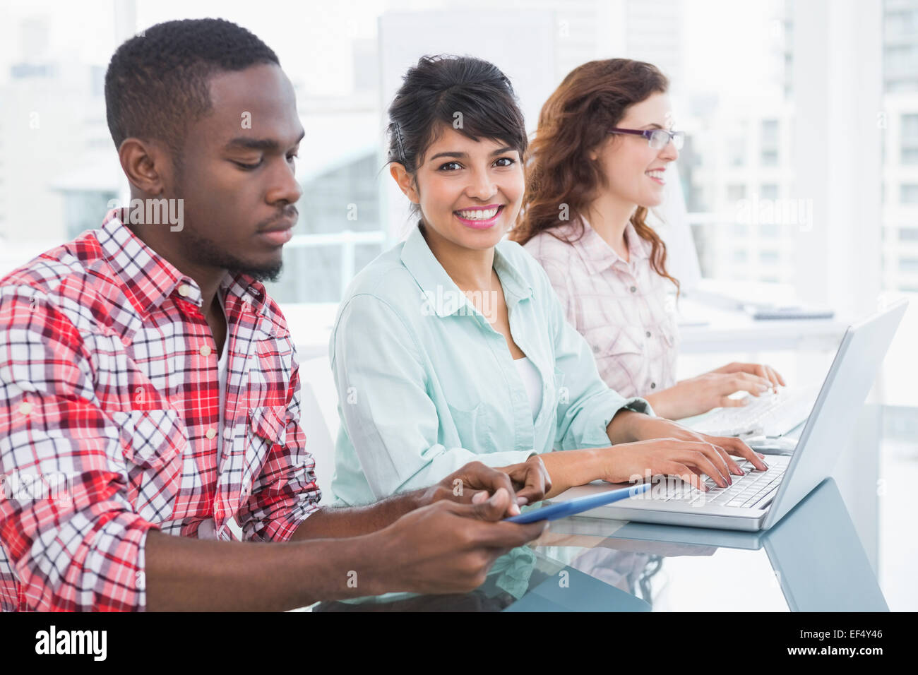 Cheerful teamwork using tablet and laptop Stock Photo - Alamy