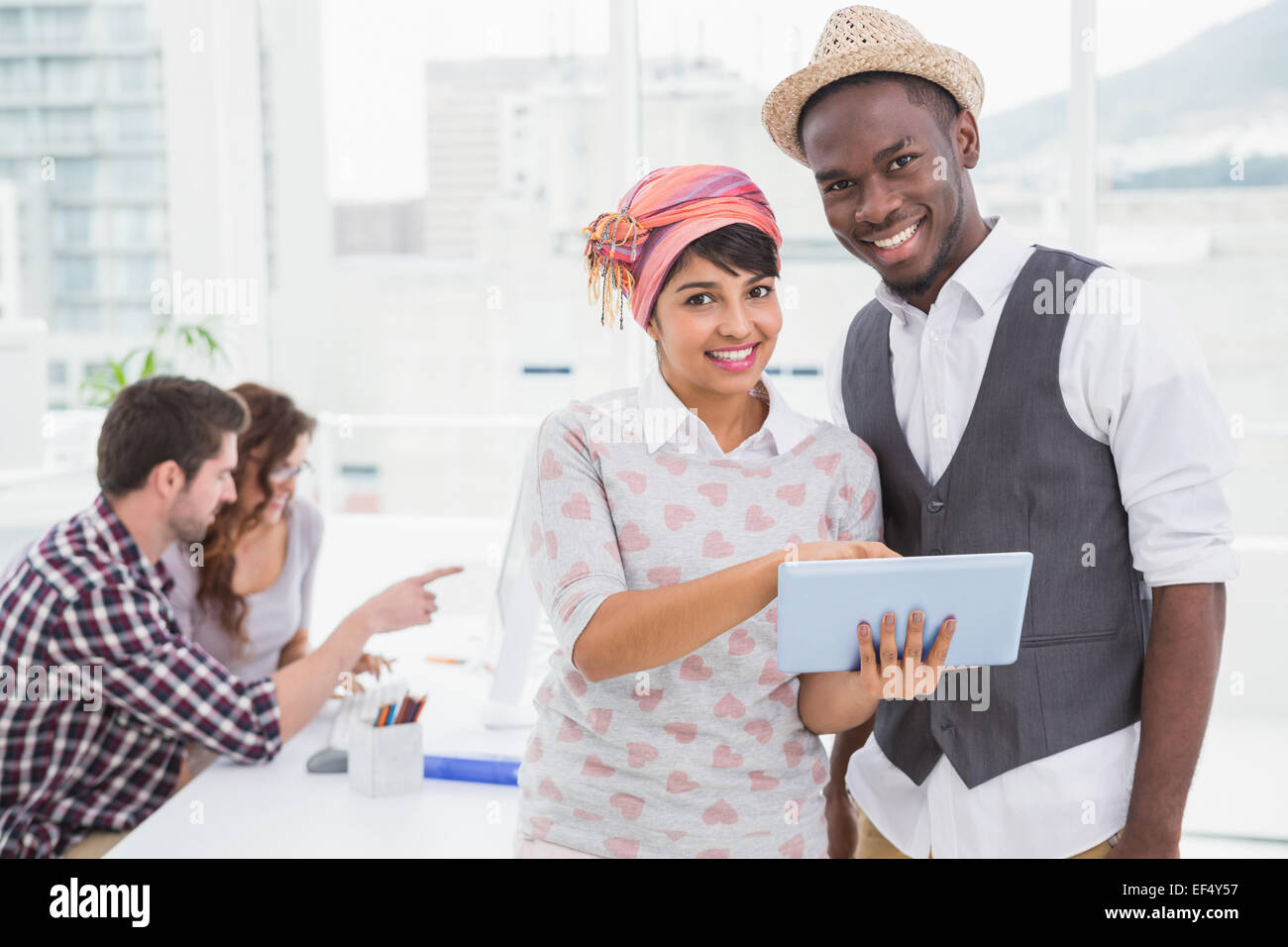 Happy teamwork standing and using tablet Stock Photo - Alamy