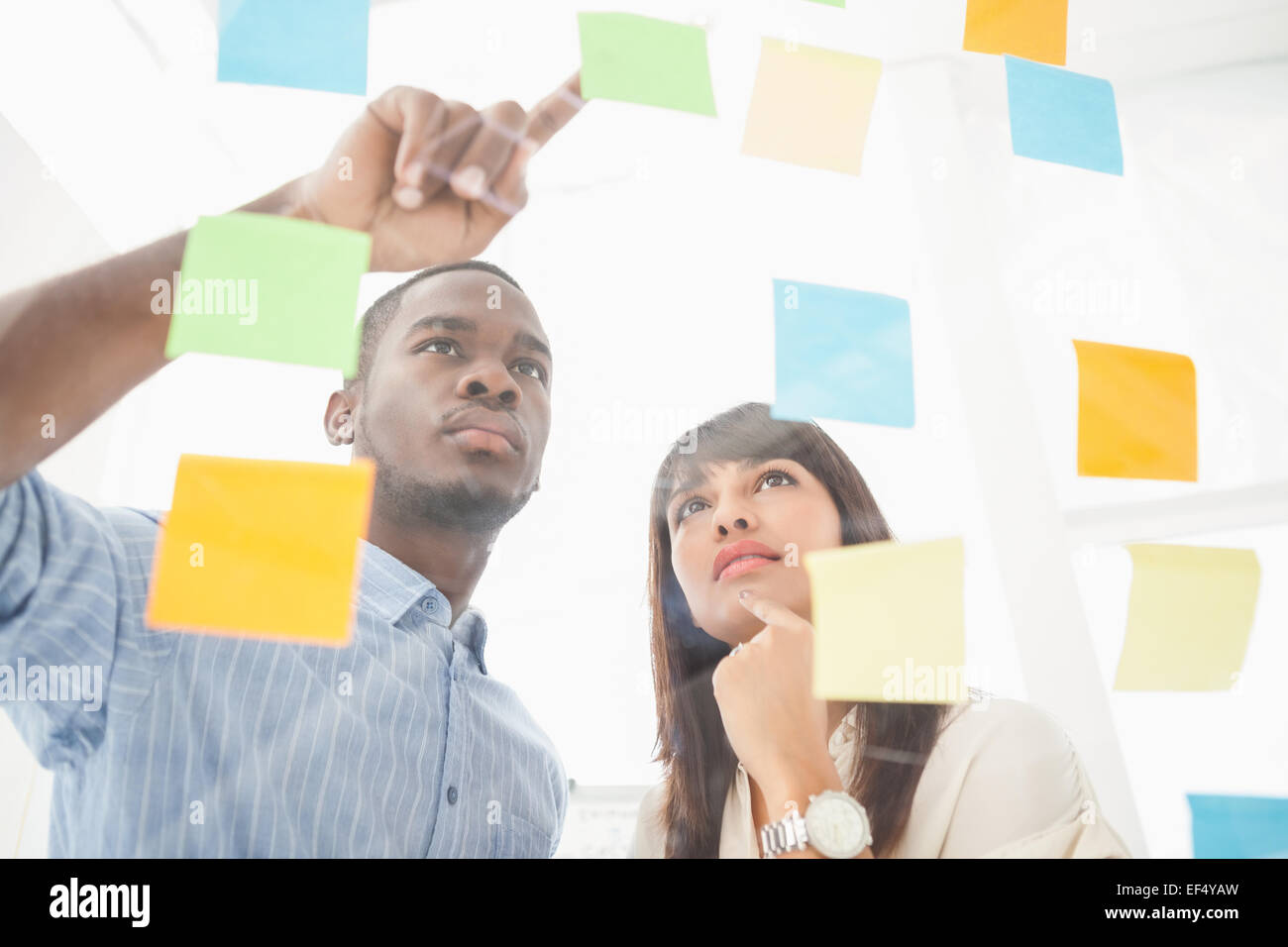 Focused teamwork looking at sticky notes Stock Photo - Alamy