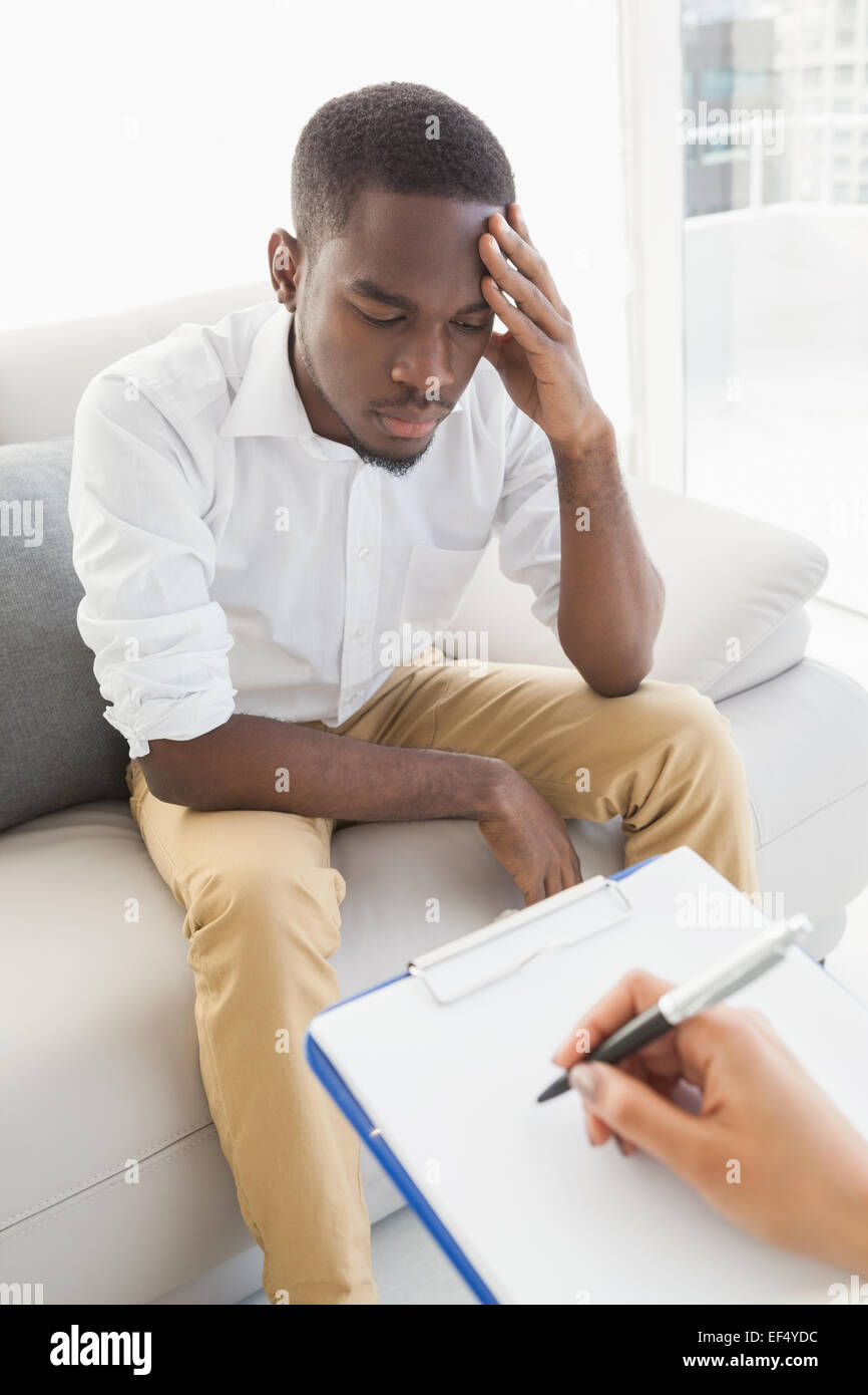 Therapist taking notes on her depressed patient Stock Photo - Alamy