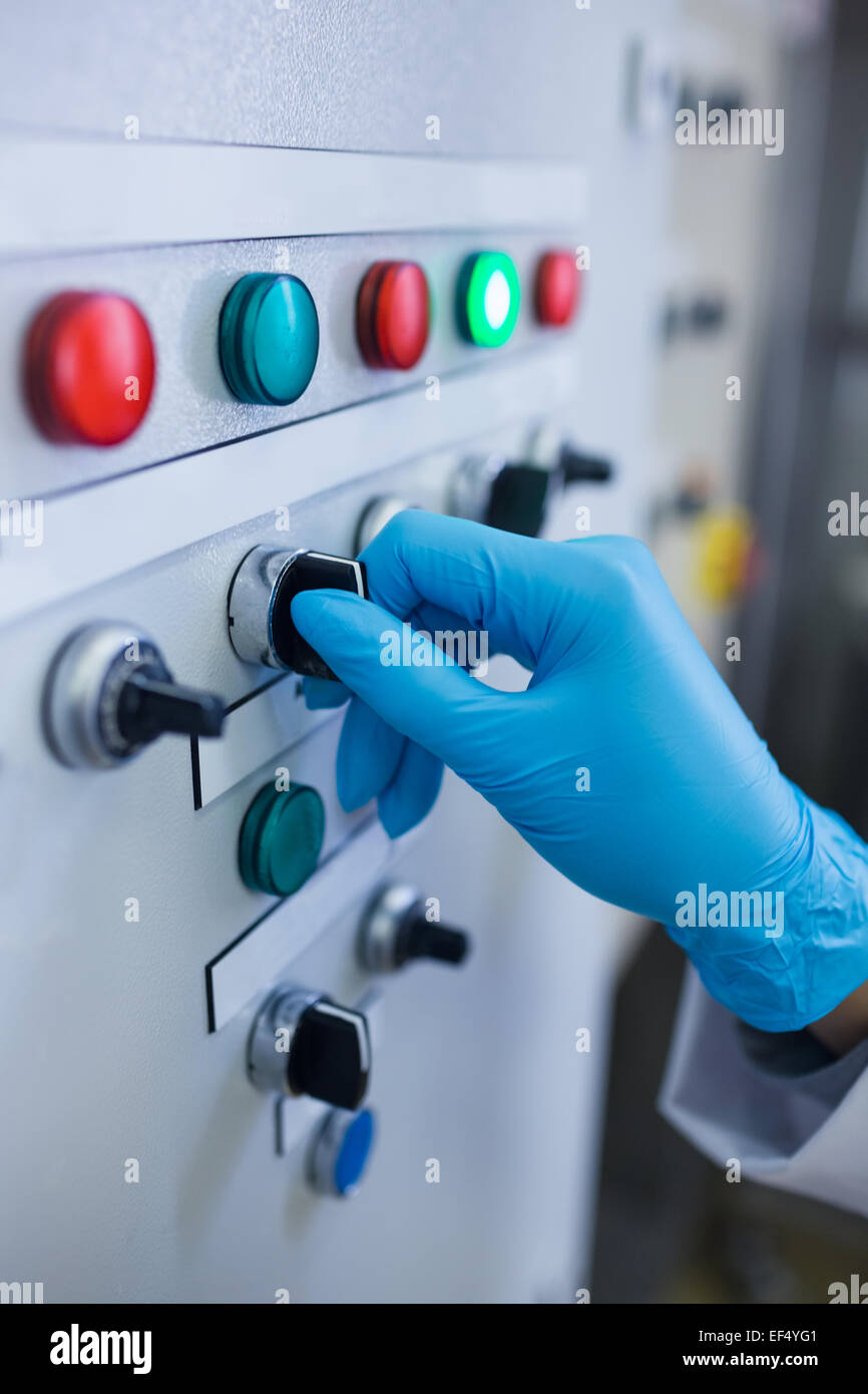 Hand with gloves turning buttons of the machine Stock Photo - Alamy