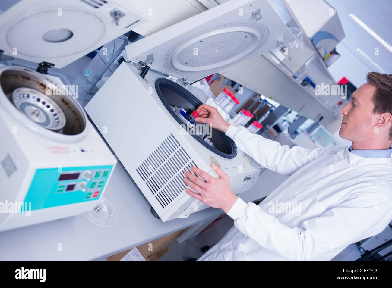 Chemist in lab coat using a centrifuge Stock Photo - Alamy