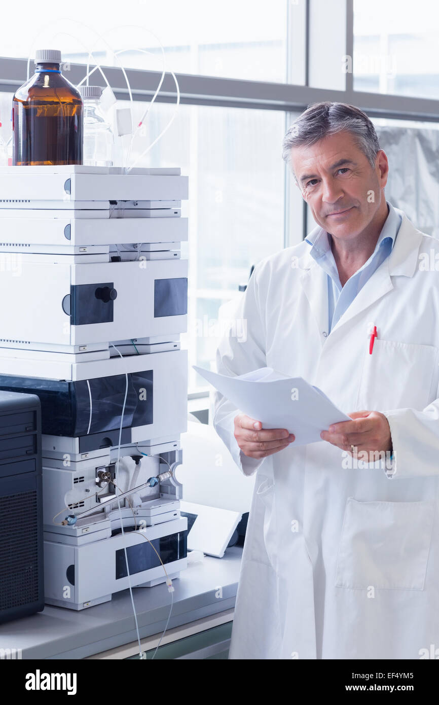 Scientist standing in lab coat holding a document Stock Photo - Alamy