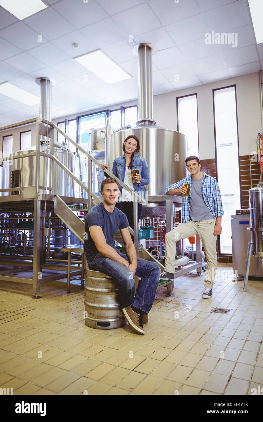 Man siting on keg and his colleague holding a glass of beer Stock Photo ...