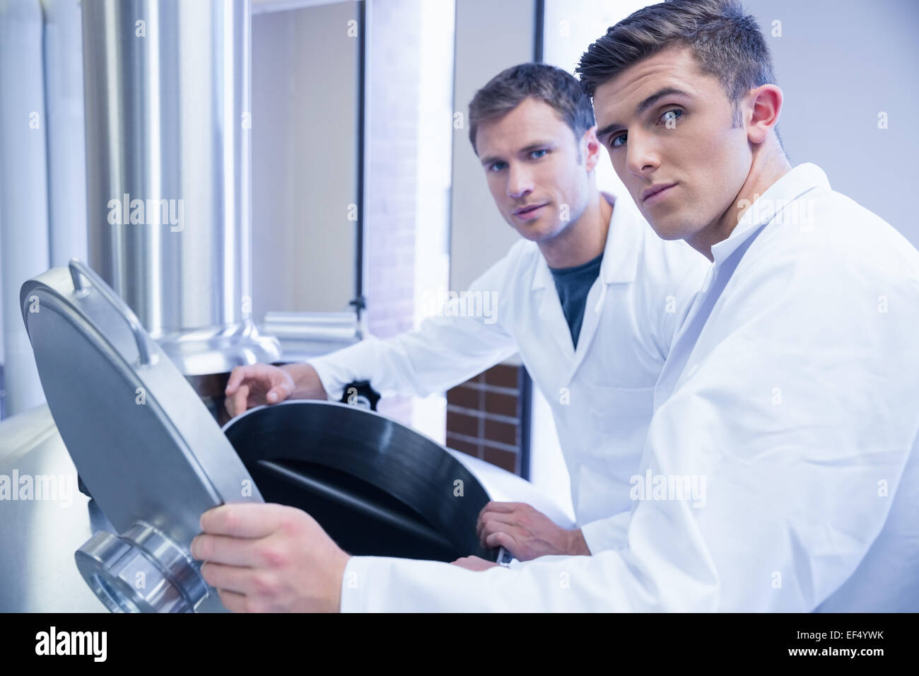 Two scientists opening the lid and looking at the camera Stock Photo ...