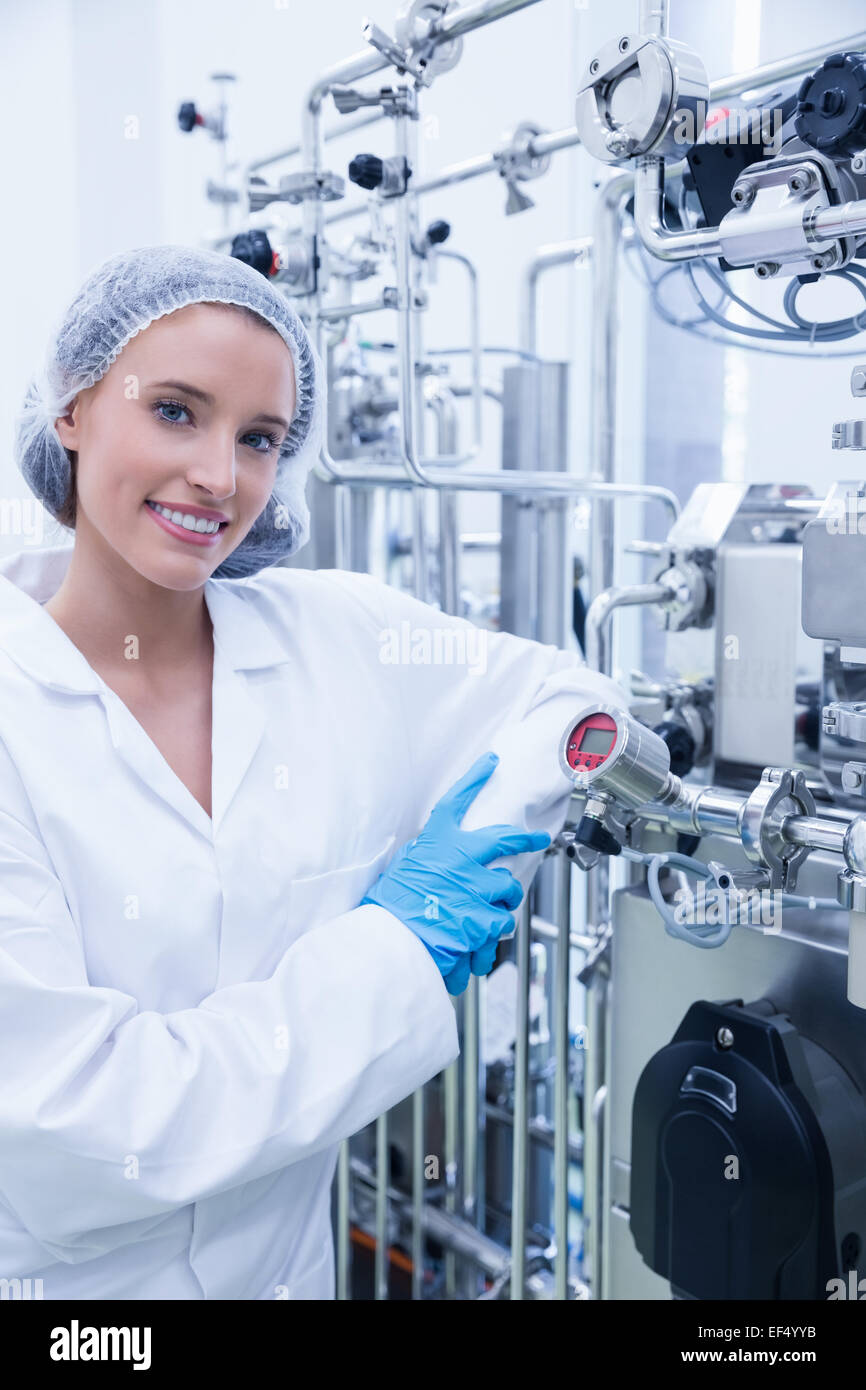 Smiling scientist leaning against gauge Stock Photo - Alamy