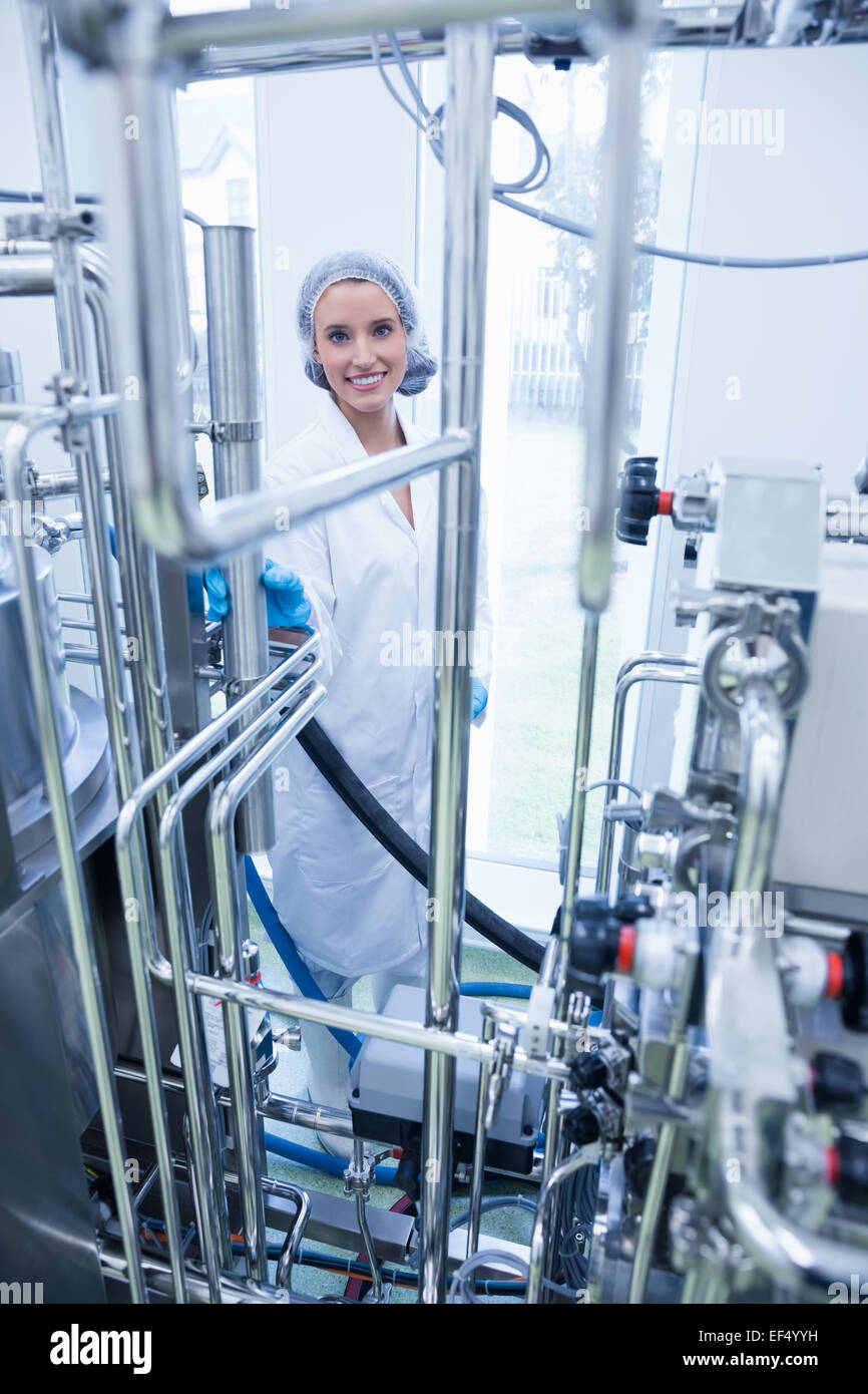 Smiling scientist behind metal pipe Stock Photo - Alamy