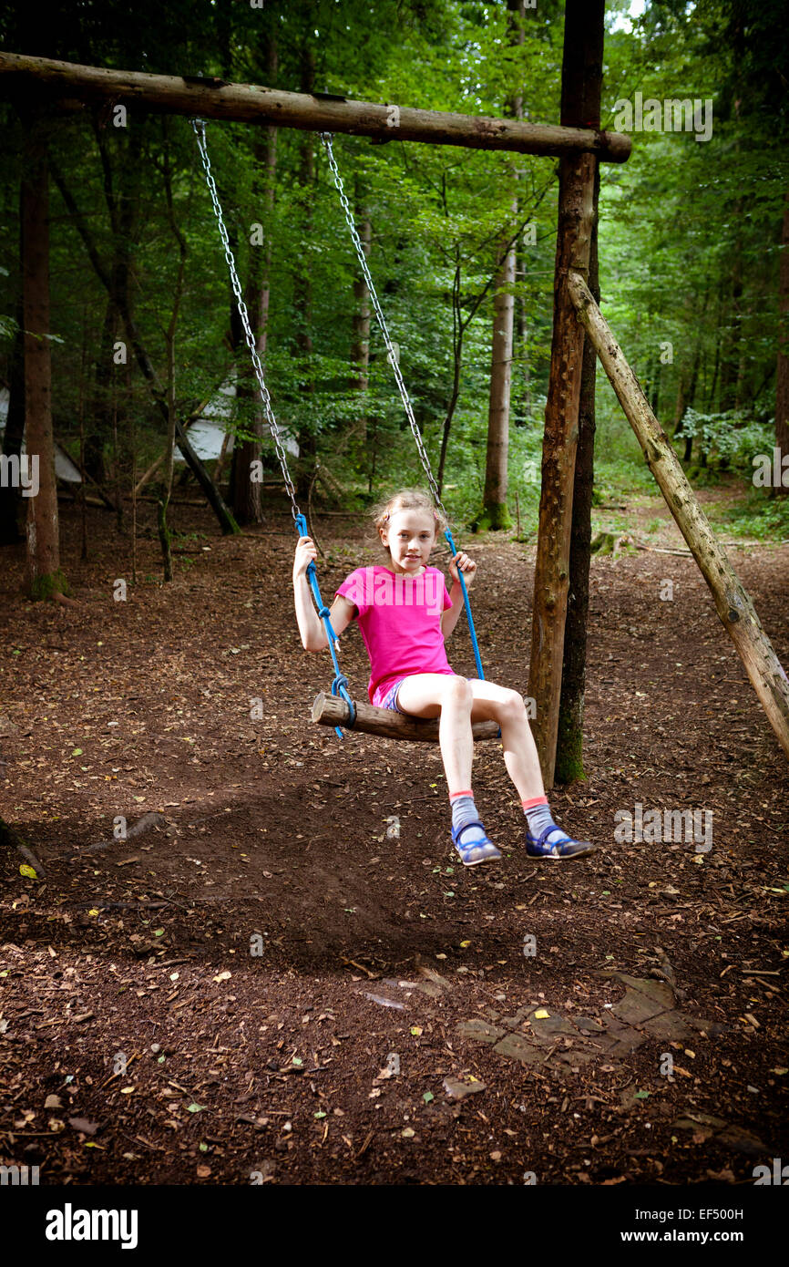 Girl playing on swing in forest camp, Munich, Bavaria, Germany Stock ...
