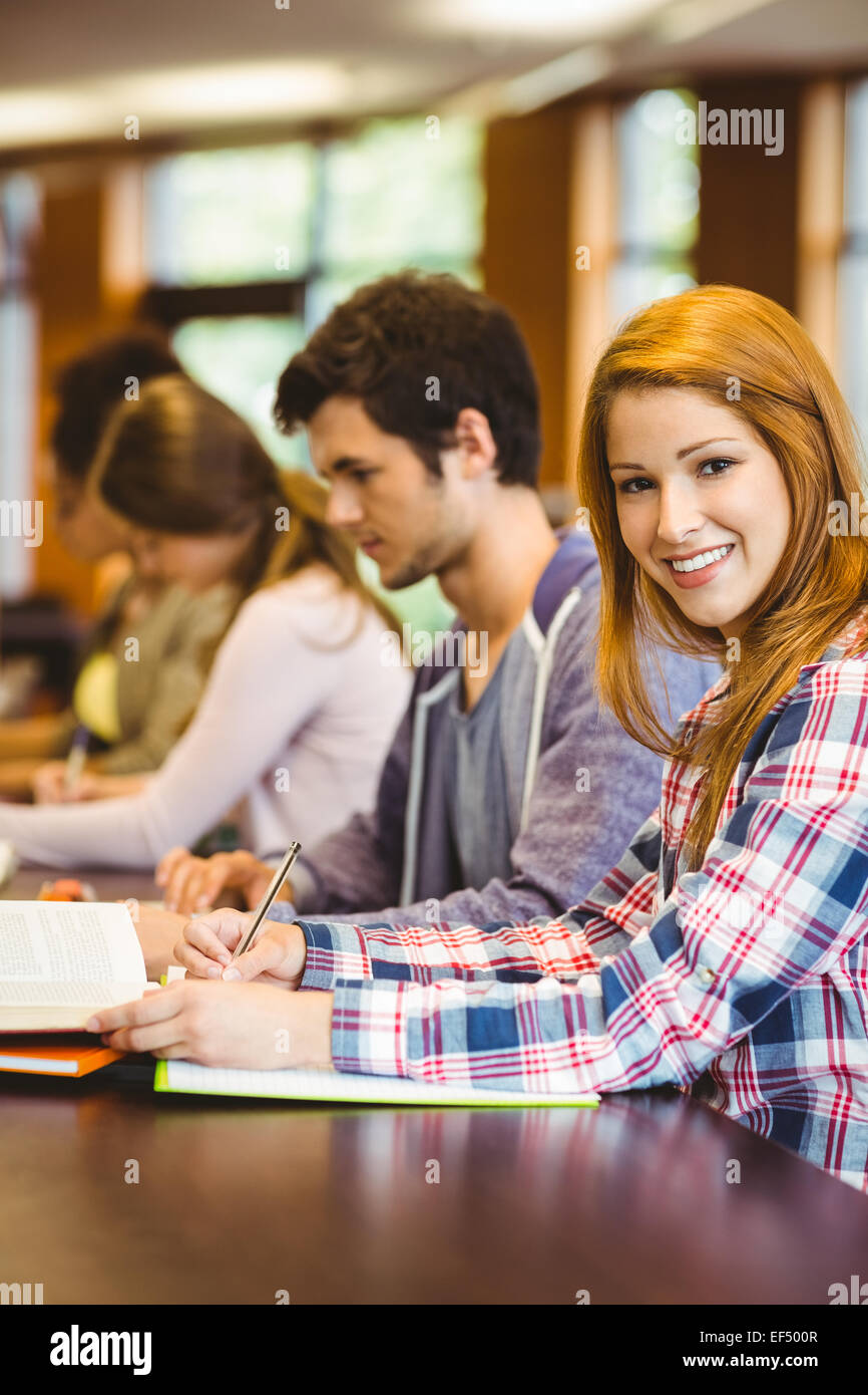 Student looking at camera while studying with classmates Stock Photo ...