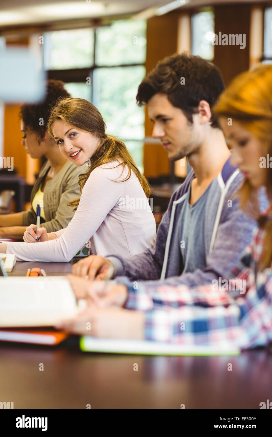 Student looking at camera while studying with classmates Stock Photo ...