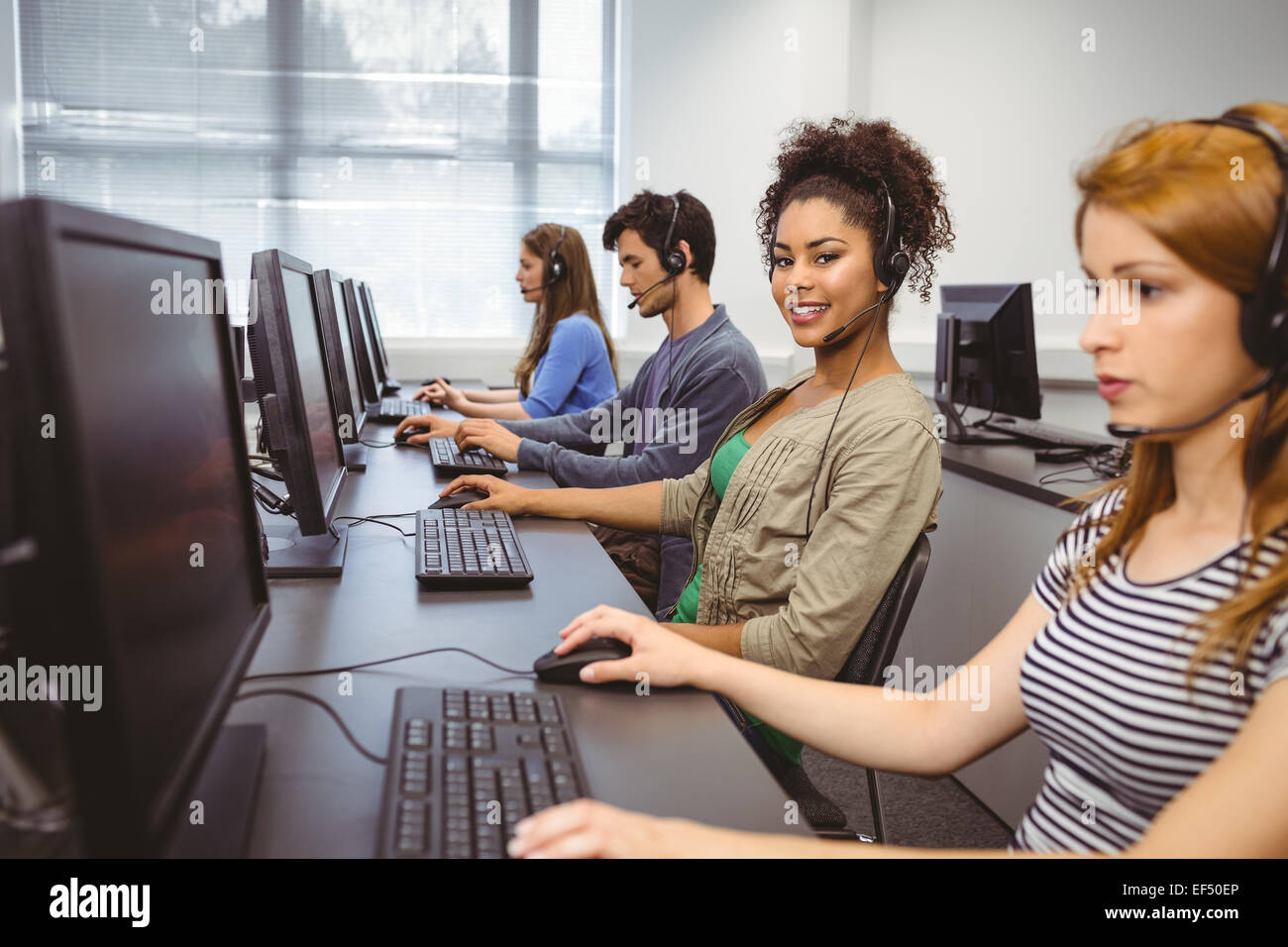 Happy student in computer class smiling at camera Stock Photo - Alamy
