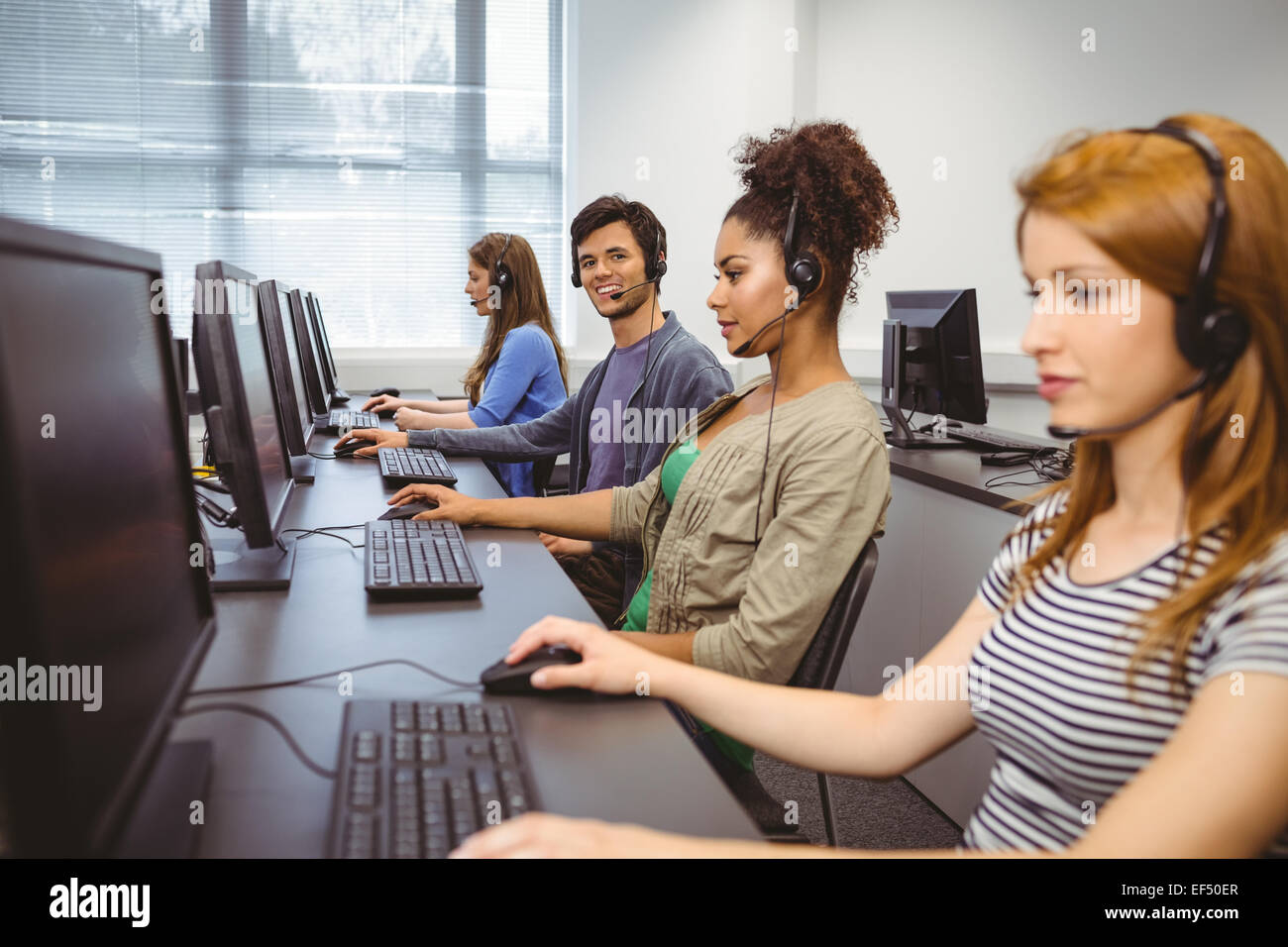 Happy student in computer class smiling at camera Stock Photo - Alamy