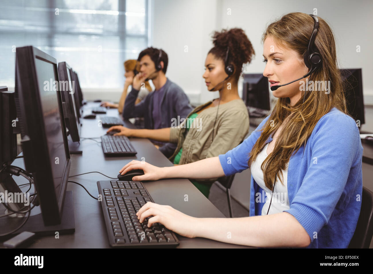Student sitting at the computer room wearing headset Stock Photo - Alamy