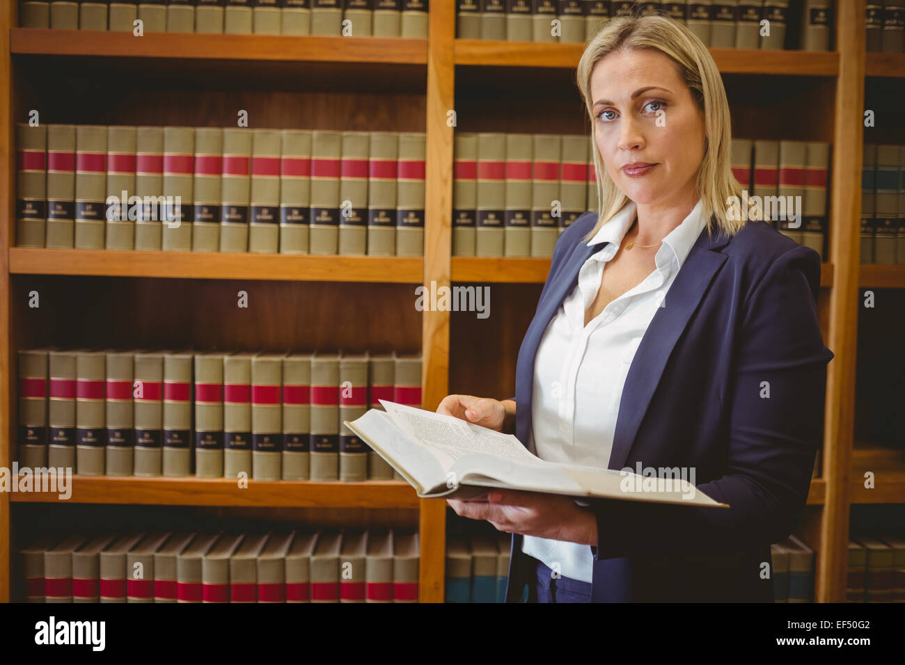 Woman reading concentrated a book standing Stock Photo - Alamy