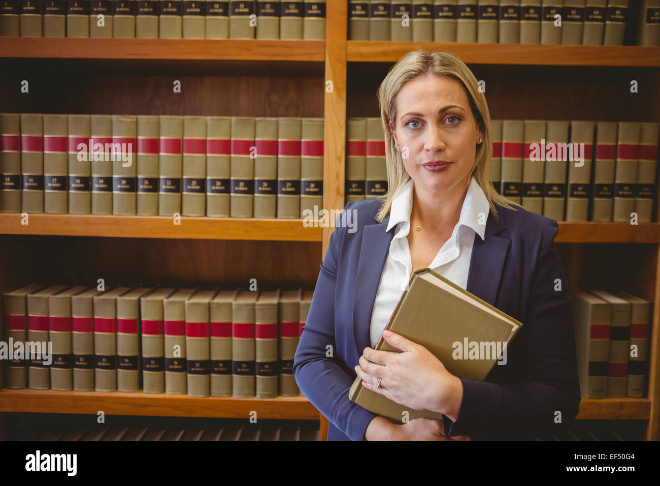 Portrait of a librarian posing and holding a book Stock Photo - Alamy