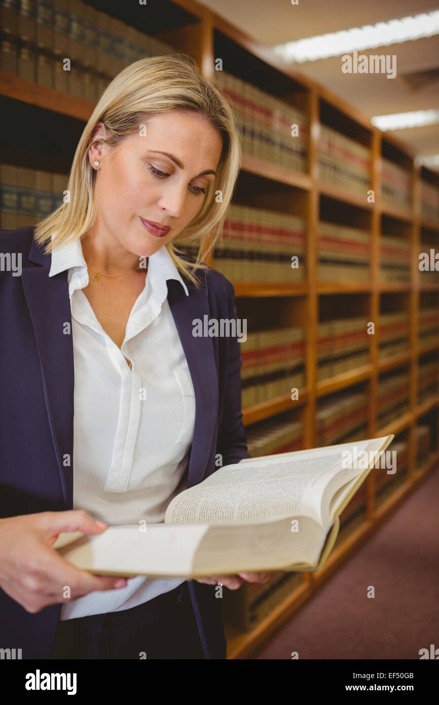 Serious librarian reading a book Stock Photo - Alamy