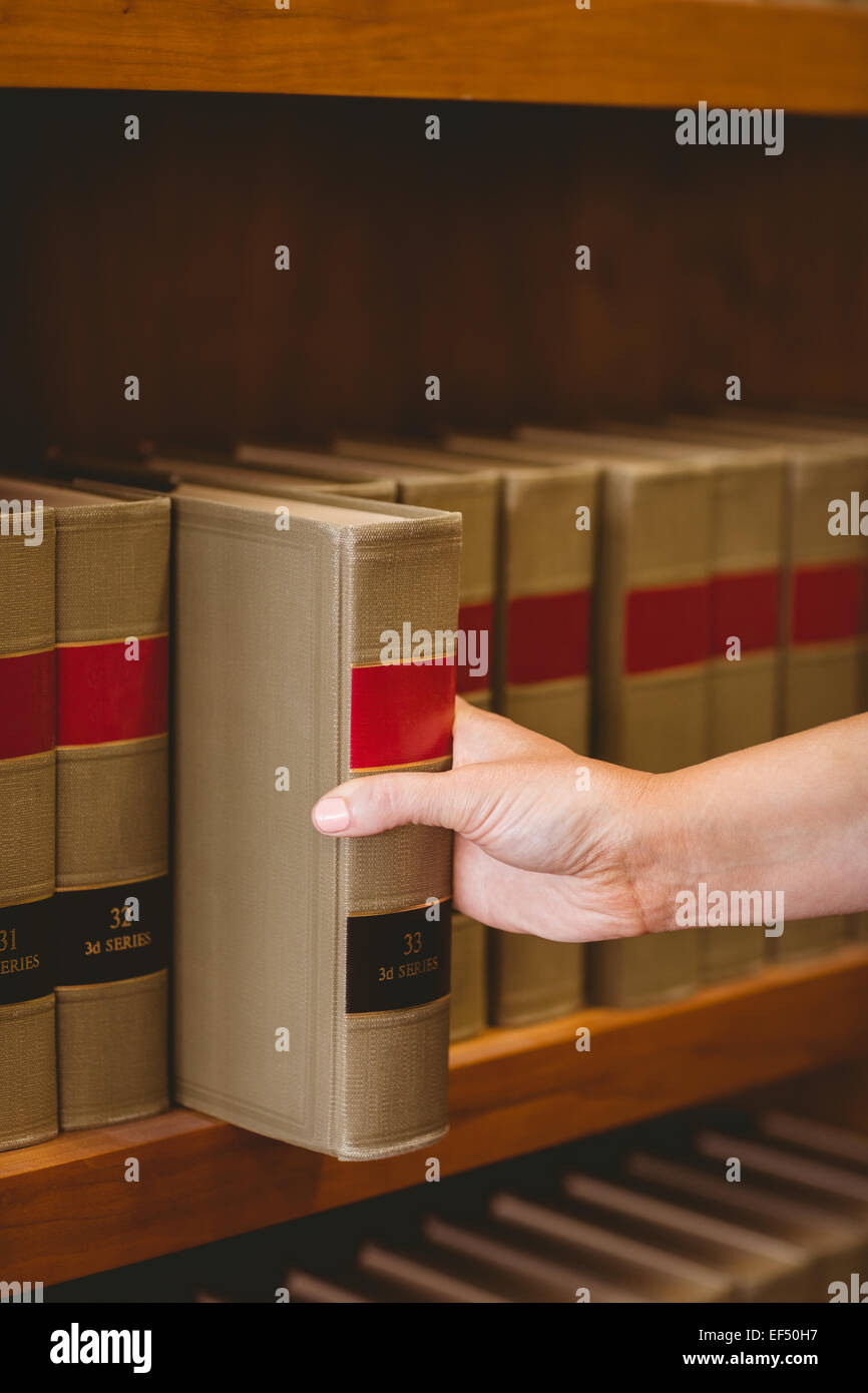 Hand taking a book from bookshelf Stock Photo - Alamy