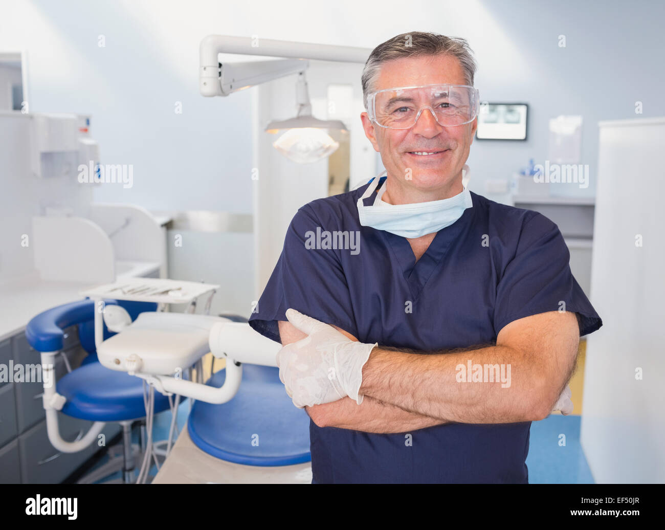 Portrait of a smiling dentist with arms crossed Stock Photo - Alamy