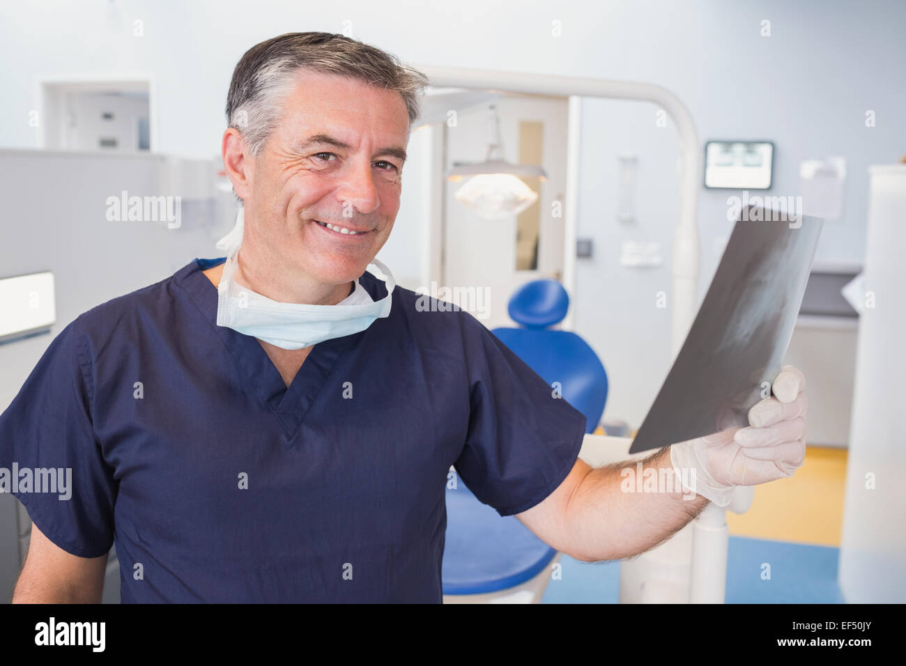 Smiling dentist examining a x-ray Stock Photo - Alamy
