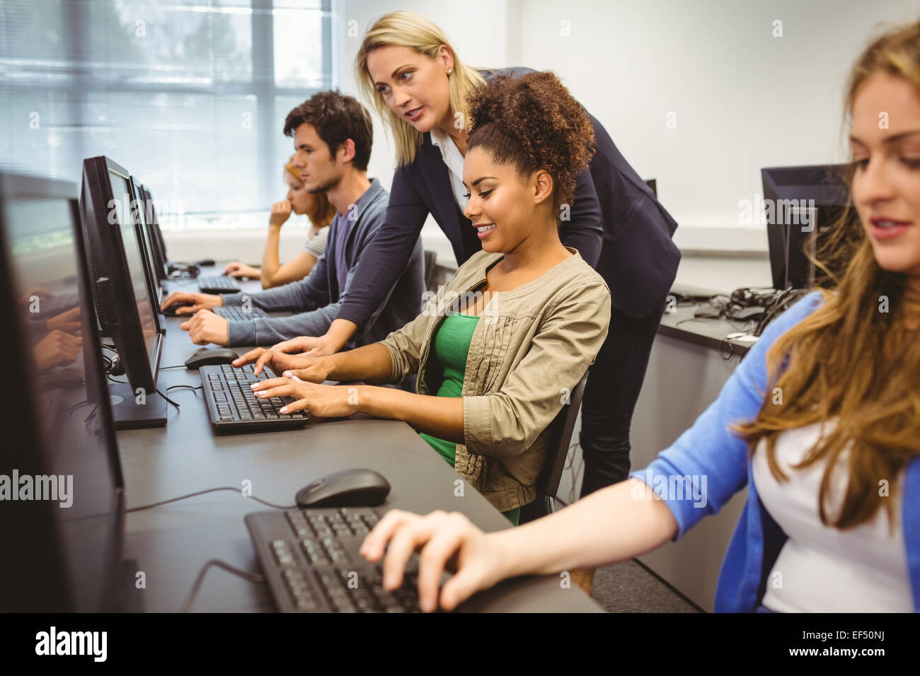 Attractive teacher helping her student in computer class Stock Photo ...