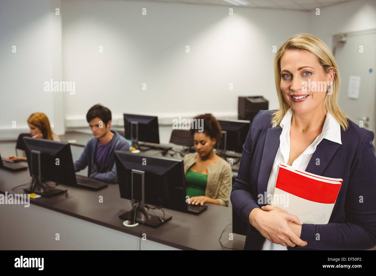 Happy computer teacher smiling at camera during her class Stock Photo ...