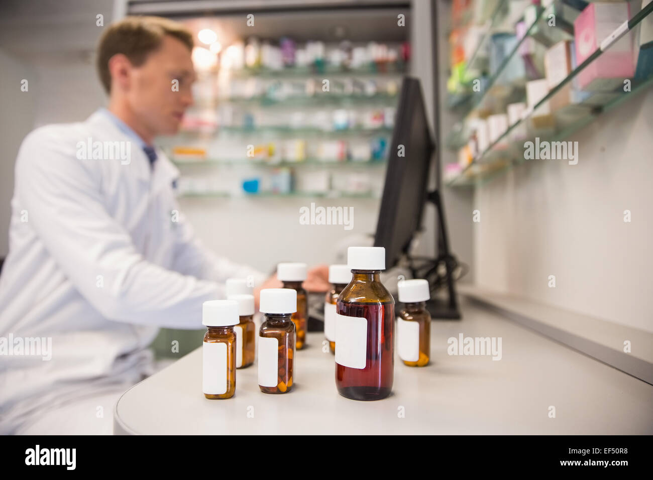 Pharmacist using computer at desk Stock Photo - Alamy
