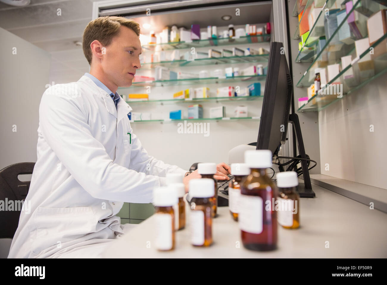 Pharmacist using computer at desk Stock Photo - Alamy