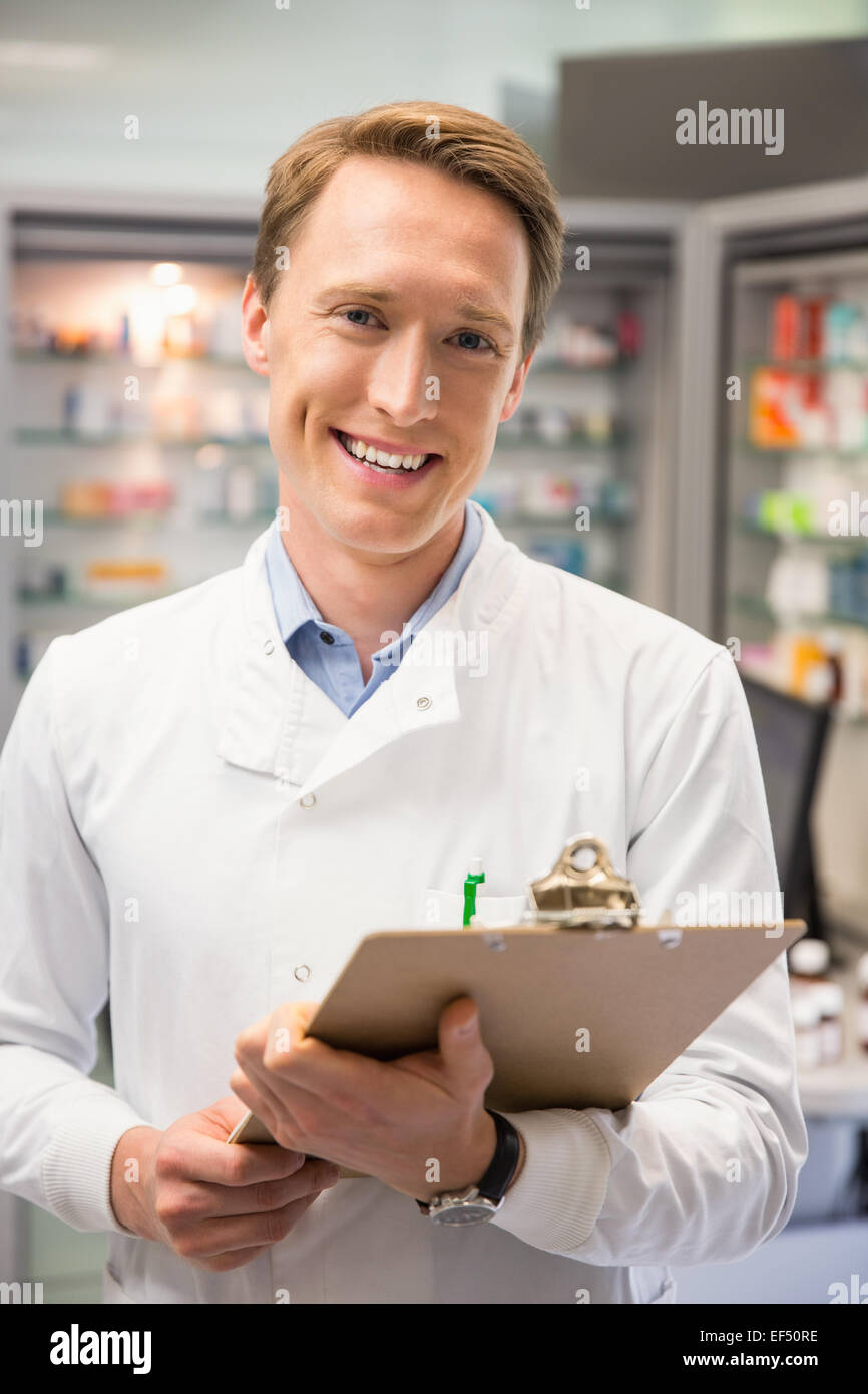 Happy pharmacist writing on clipboard Stock Photo - Alamy