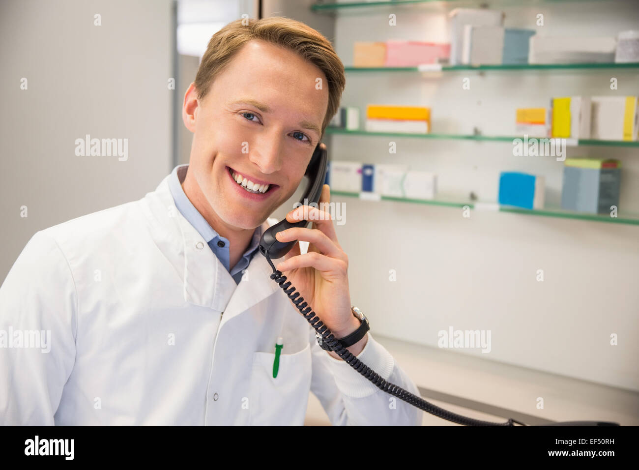 Happy pharmacist on the phone using computer Stock Photo - Alamy