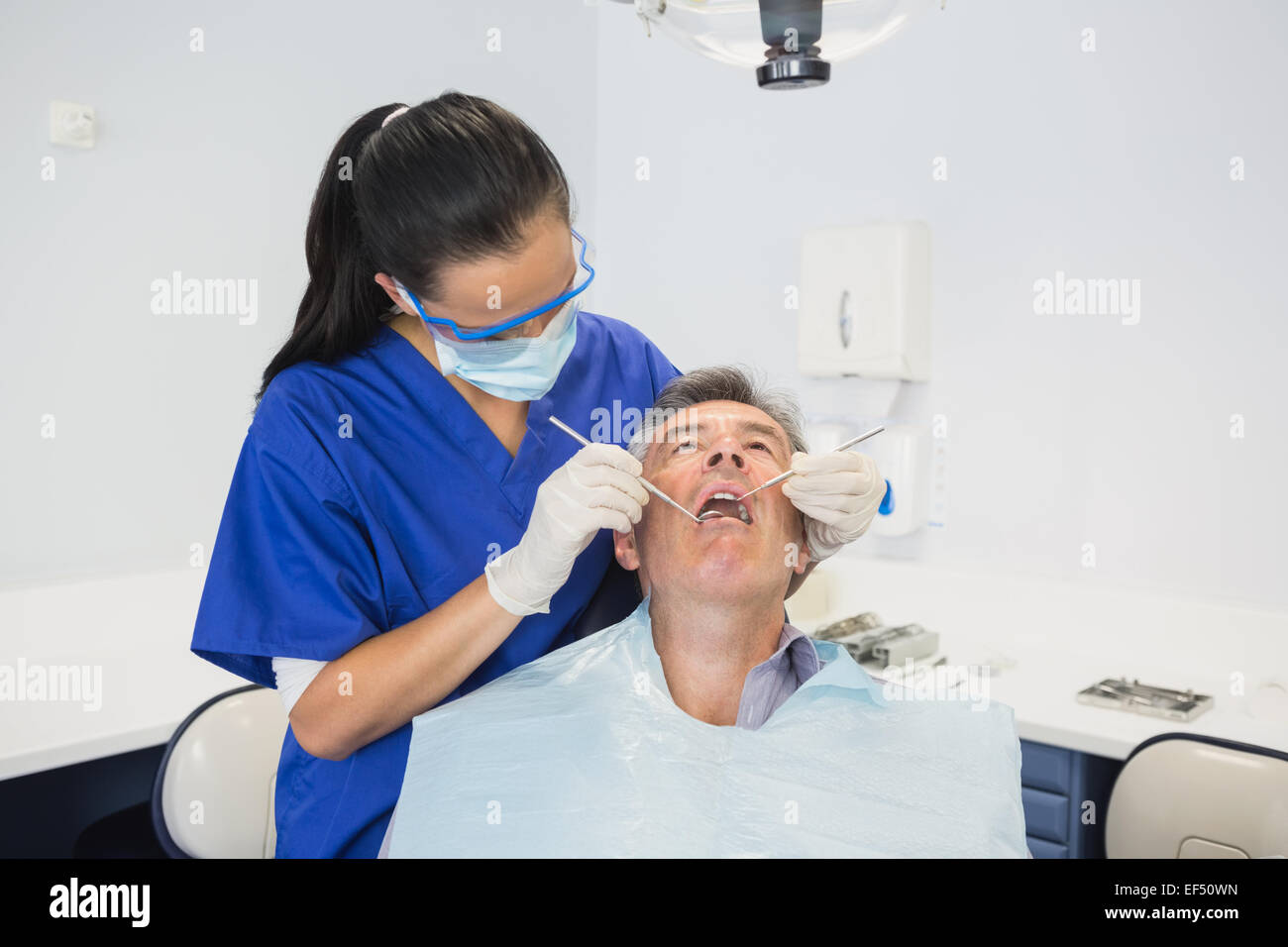 Dentist examining a patient Stock Photo - Alamy