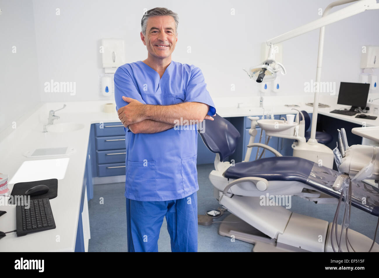 Happy dentist standing with arms crossed Stock Photo - Alamy