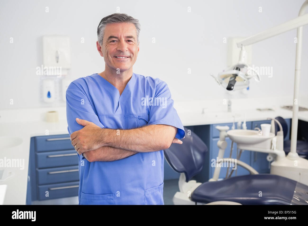Portrait of a friendly dentist with arms crossed Stock Photo - Alamy