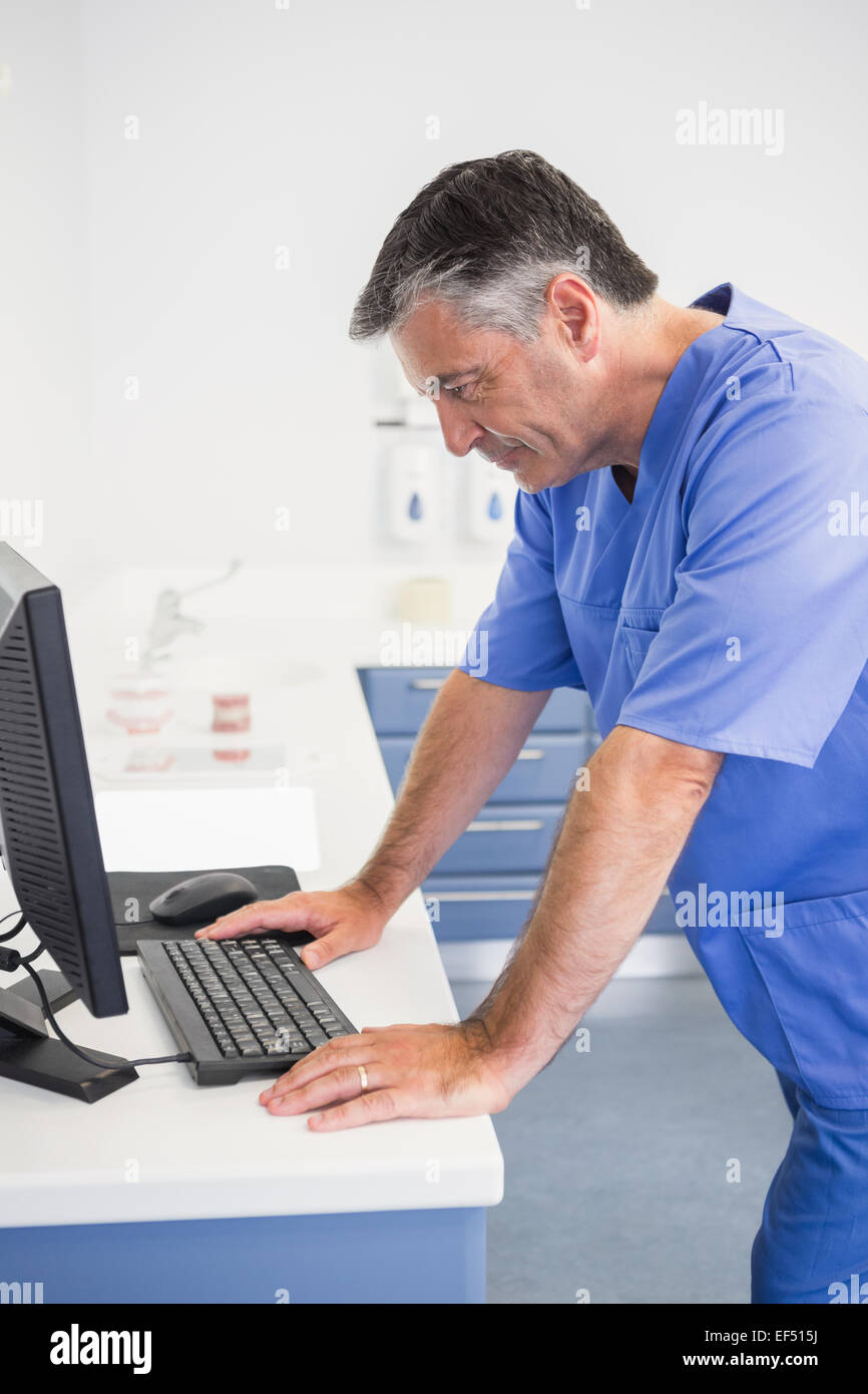 Dentist concentrated about computer monitor Stock Photo - Alamy