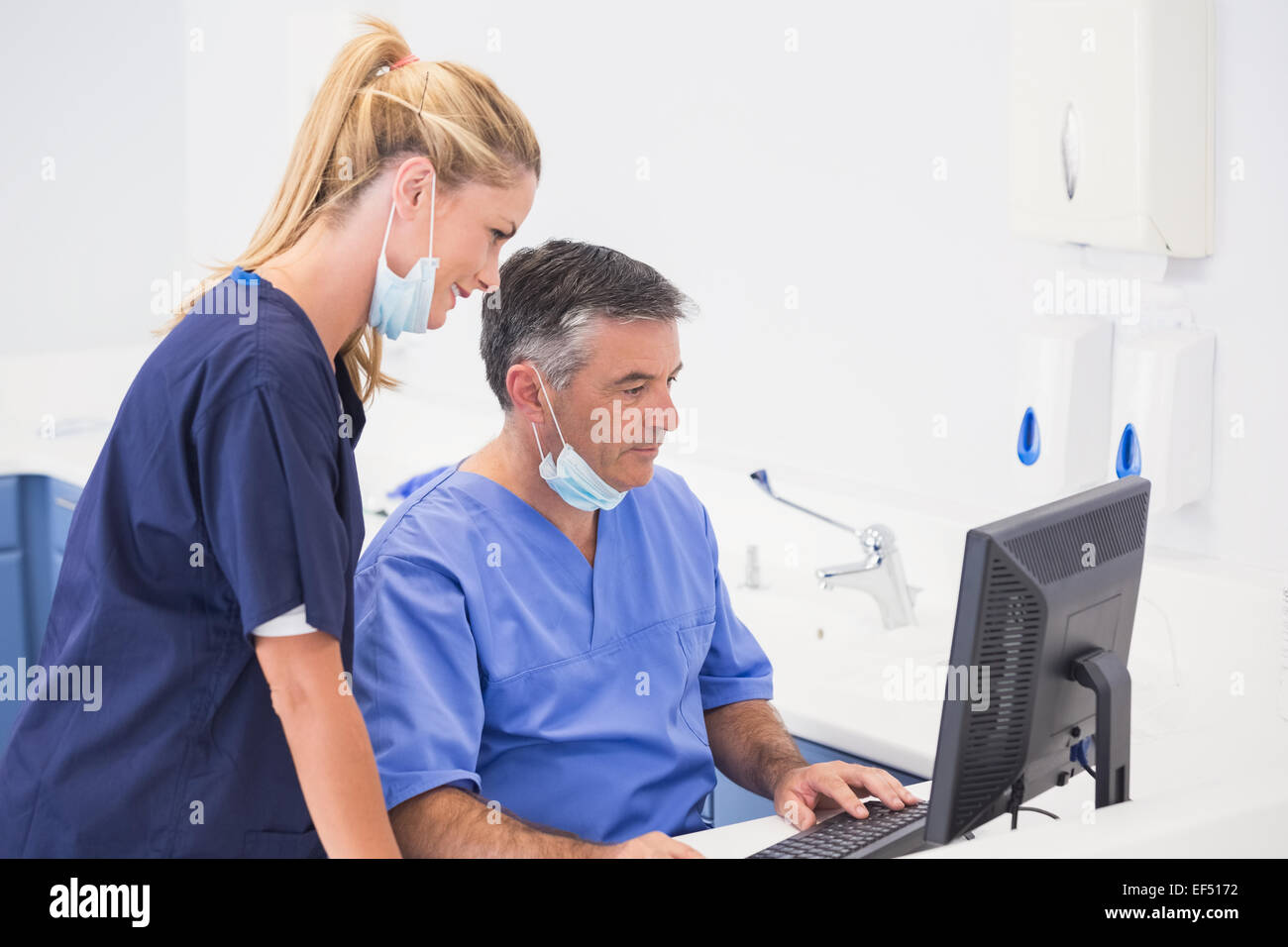 Smiling co-workers using computer Stock Photo - Alamy