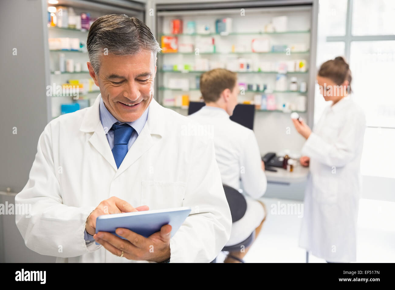 Senior pharmacist using tablet pc Stock Photo - Alamy