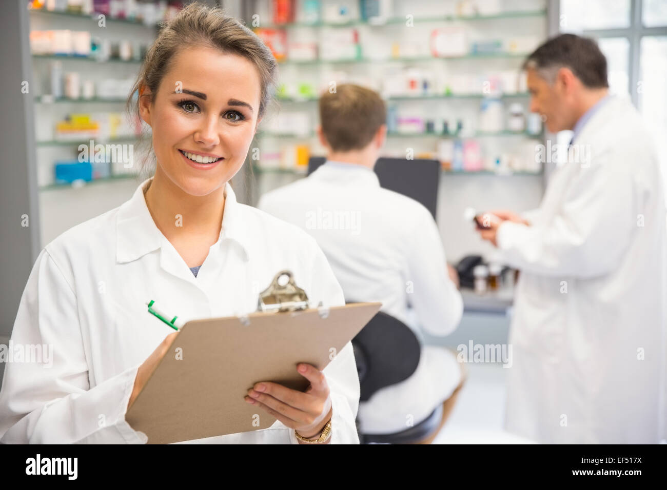 Junior pharmacist writing on clipboard Stock Photo - Alamy