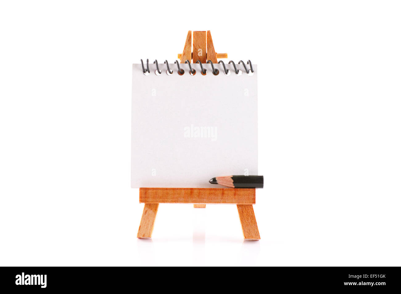 Wooden easel with pencil and spiral notebook isolated on white ...