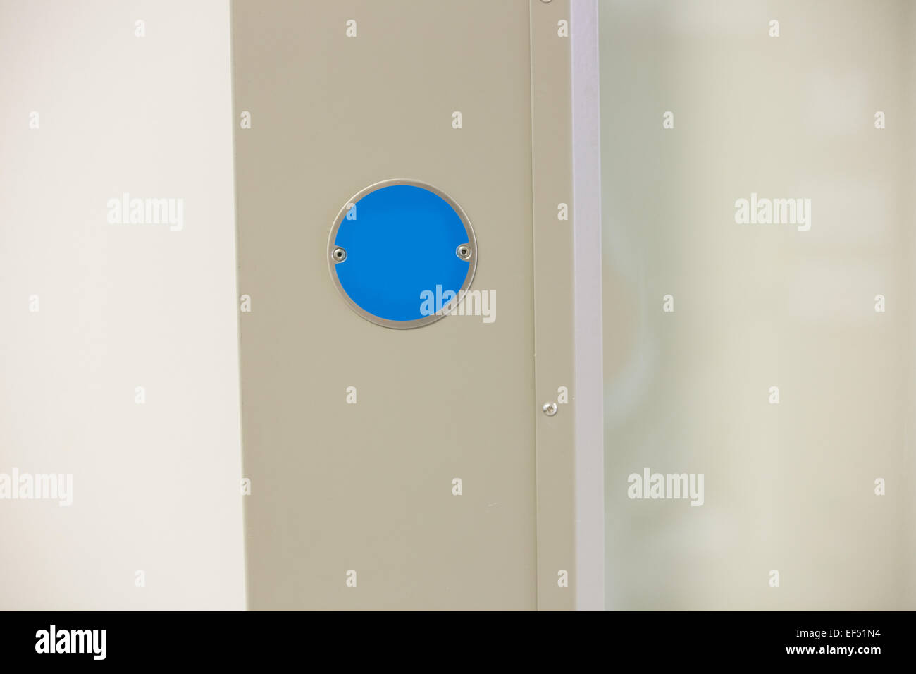 Blue button on the wall Stock Photo - Alamy