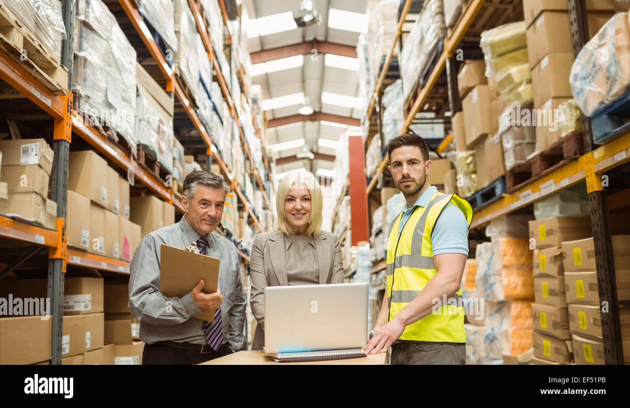 Warehouse team working together on laptop Stock Photo - Alamy