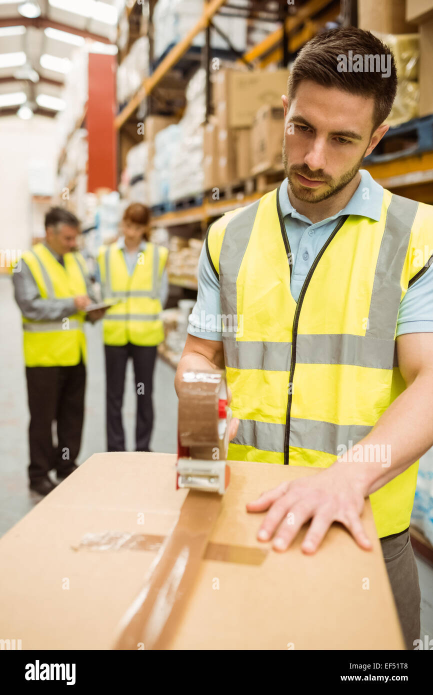 Warehouse worker sealing cardboard boxes for shipping Stock Photo - Alamy