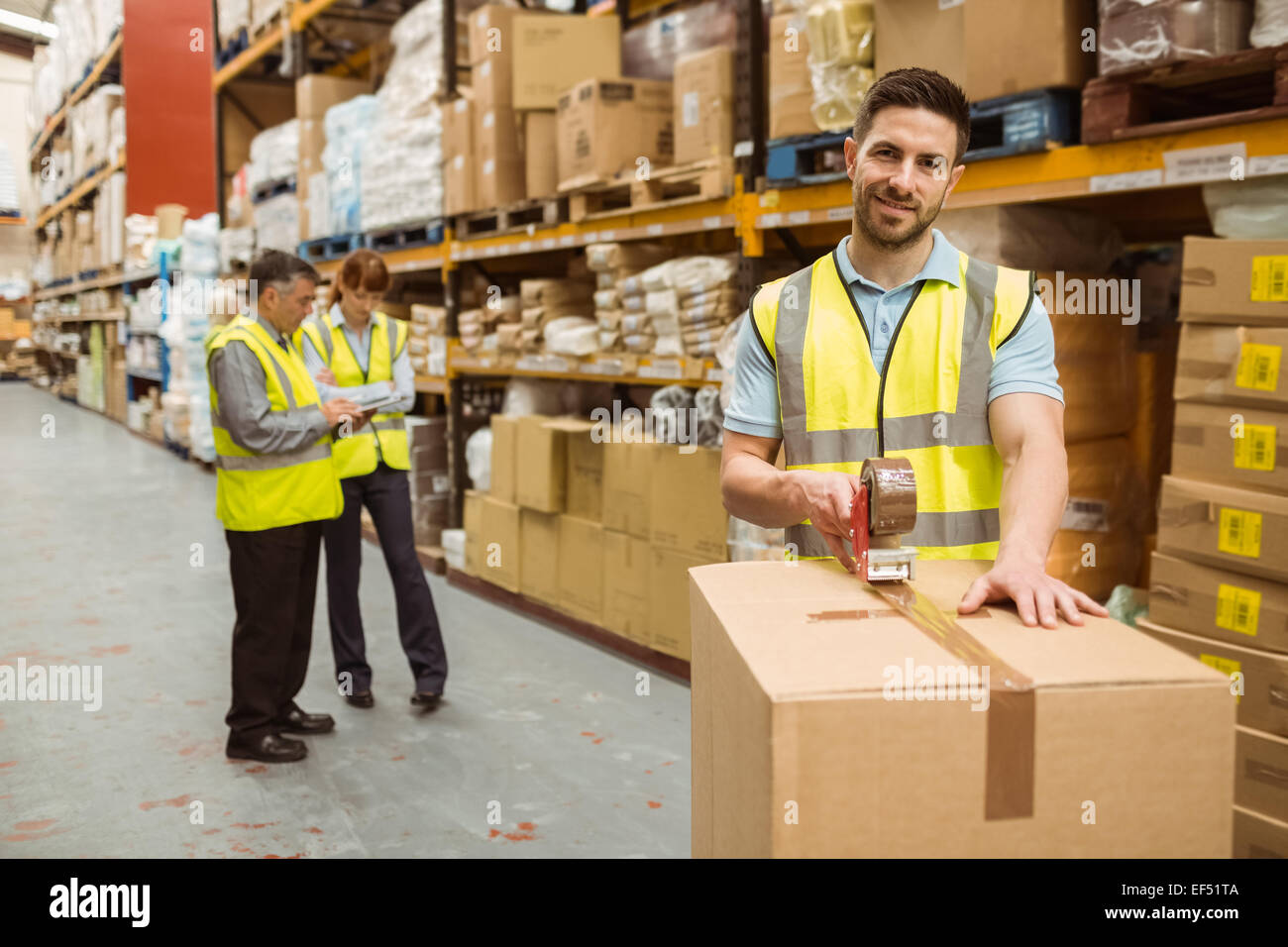 Smiling warehouse workers preparing a shipment Stock Photo - Alamy