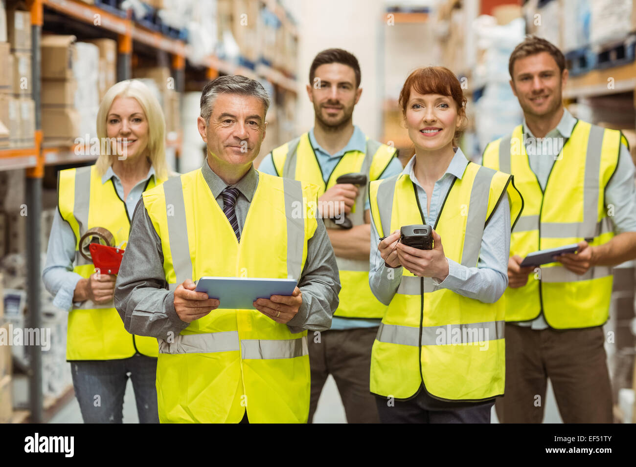 Smiling warehouse team looking at camera Stock Photo - Alamy