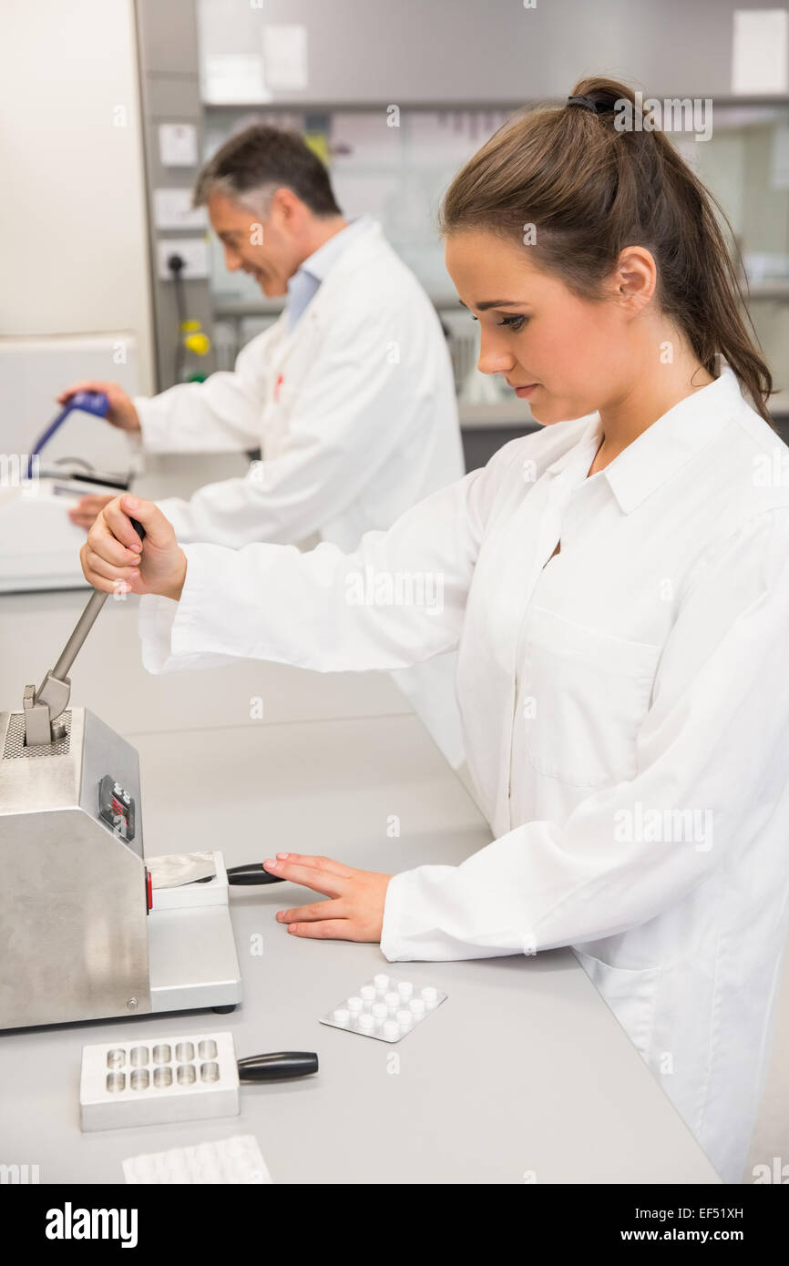 Pharmacist using press to make pills Stock Photo - Alamy