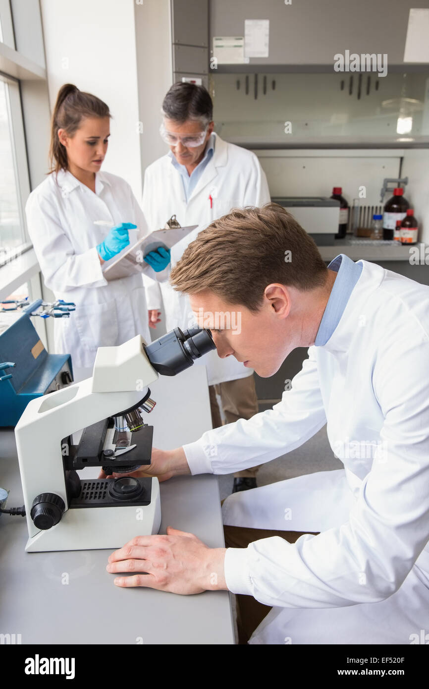 Scientist looking through a microscope Stock Photo - Alamy